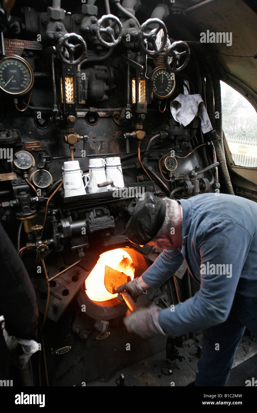Stoking fire on steam engine. Bluebell Railway, East Sussex Stock Photo ...