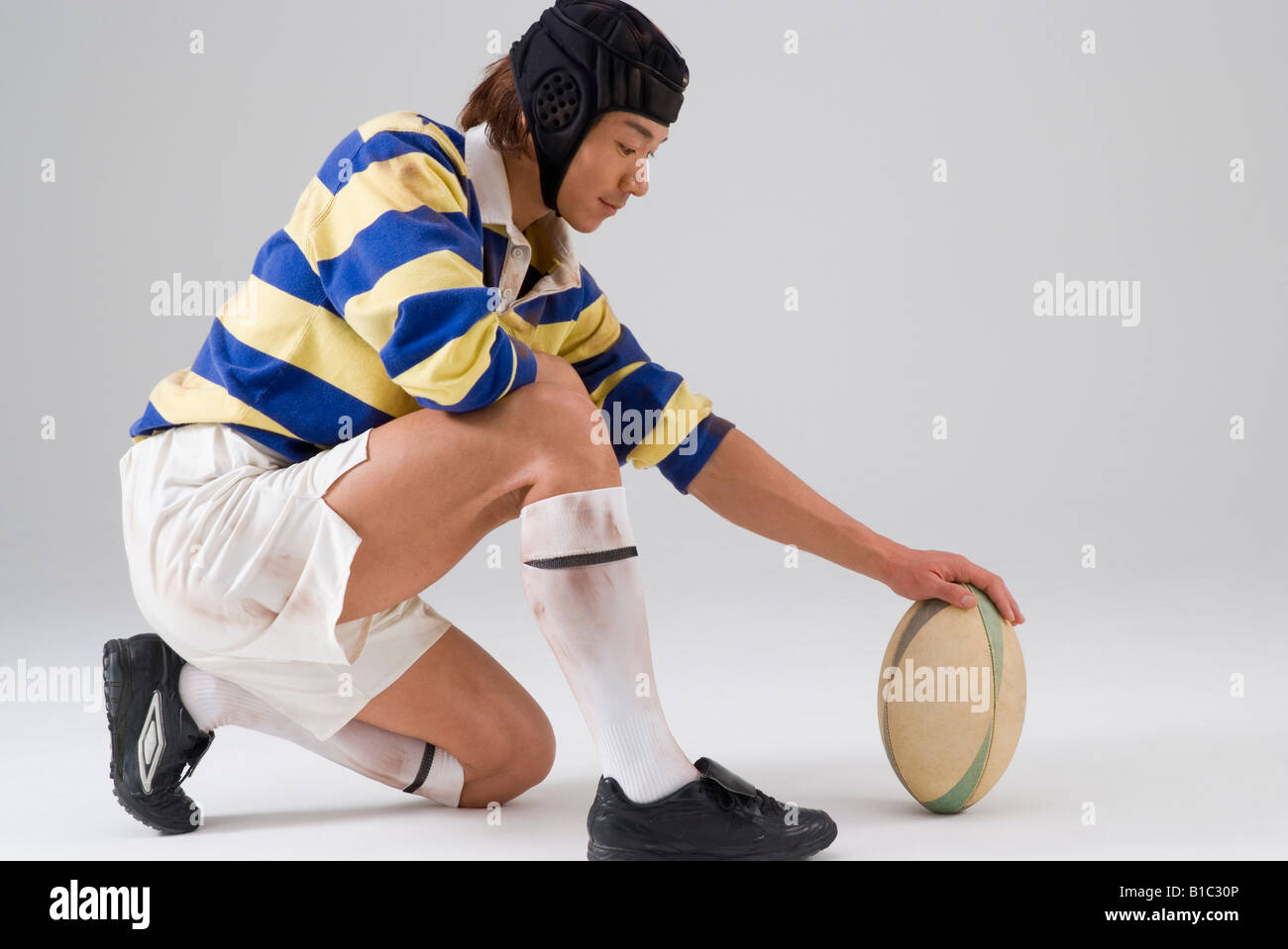 Rugby player placing ball Stock Photo - Alamy