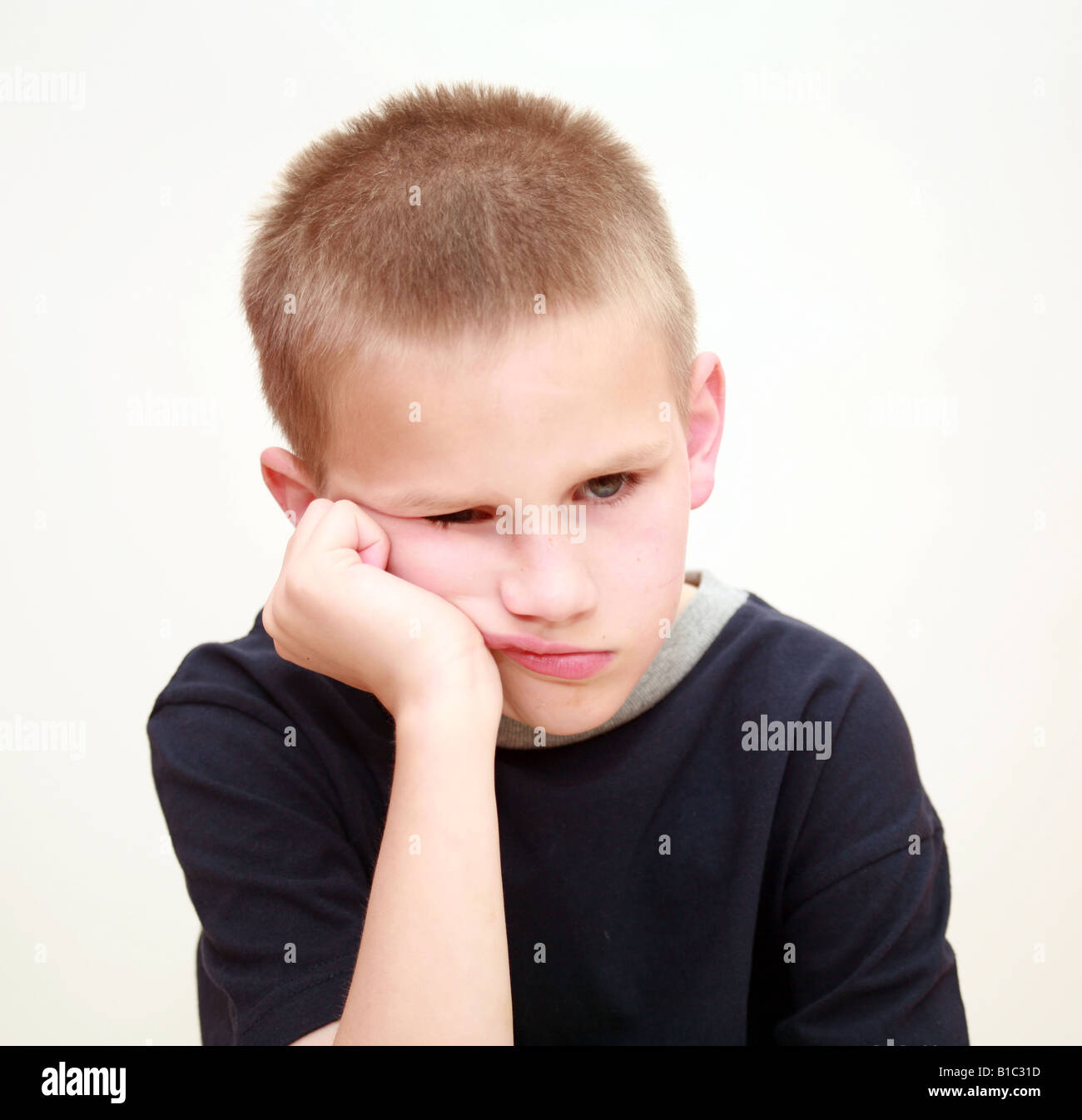 boy in studio with head on hand looking bored Stock Photo - Alamy