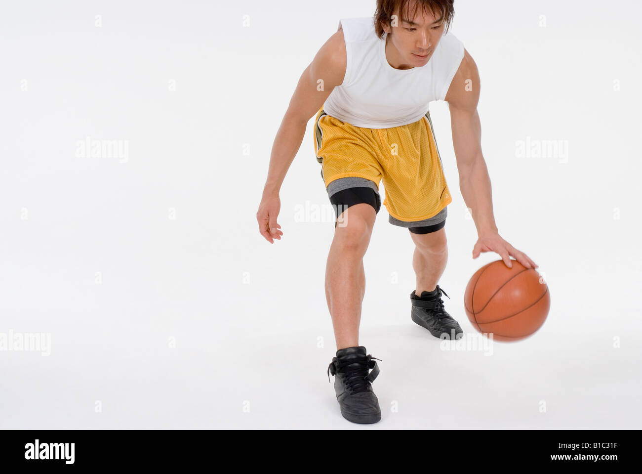 Basketball player bouncing ball Stock Photo - Alamy