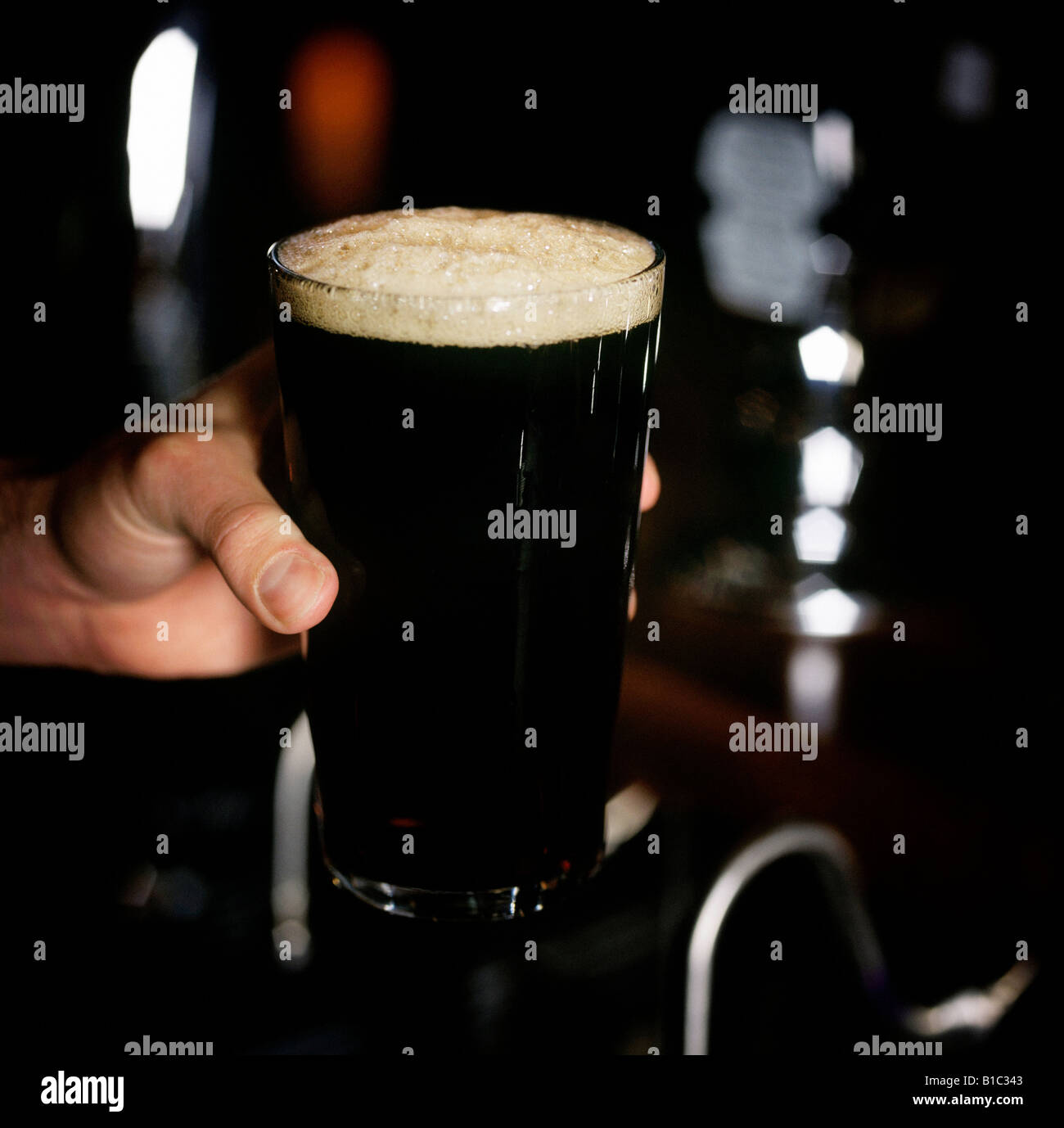 a hand holding a pint of bitter Stock Photo - Alamy