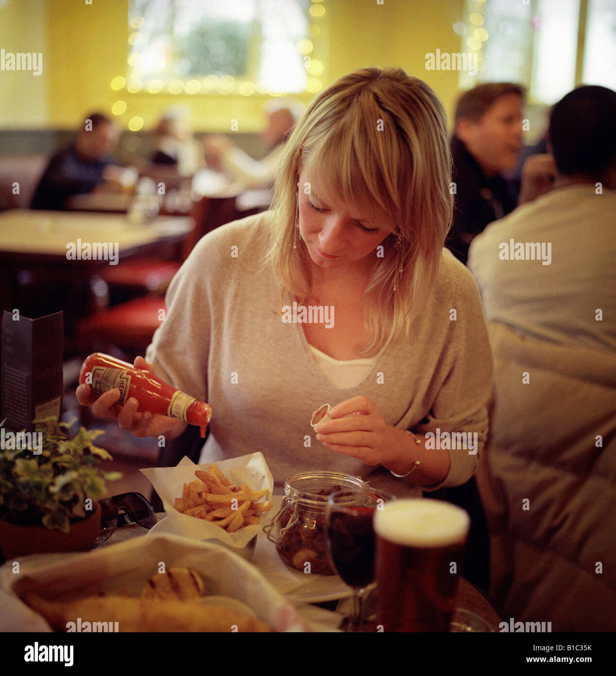 a young lady eating in a pub Stock Photo - Alamy