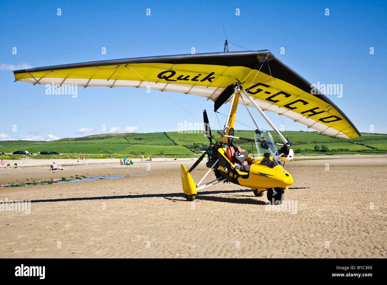 A yellow Quik microlight aircraft on the beach at Ettrick Bay, Isle of ...