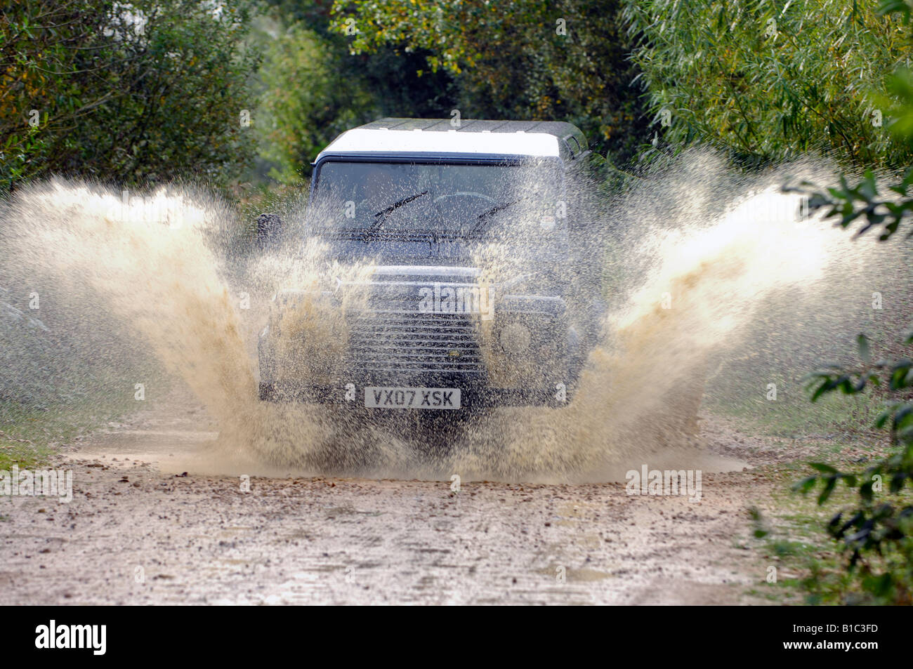 blue land rover defender being driven off road in the english ...