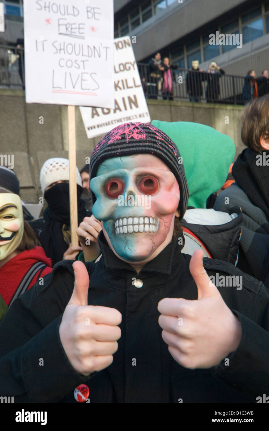 Man in mask holding placard gives thumbs up sign at 'Anonymous' protest ...