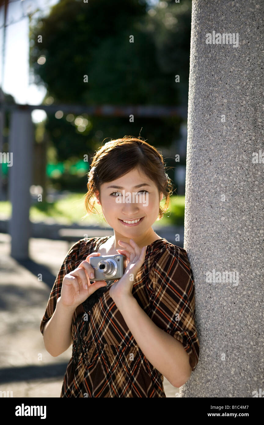 Young woman holding digital camera Stock Photo - Alamy