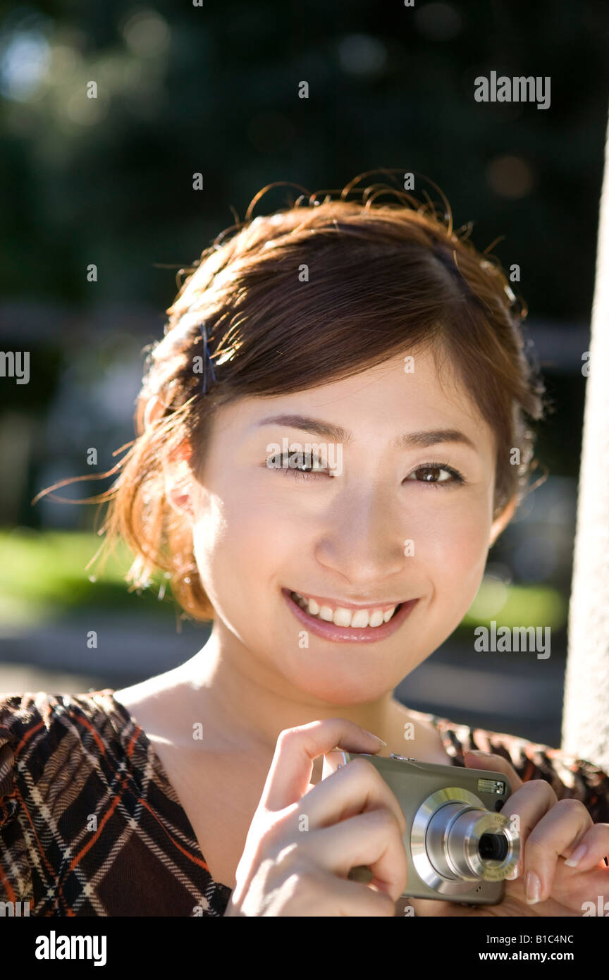 Young woman holding digital camera Stock Photo - Alamy