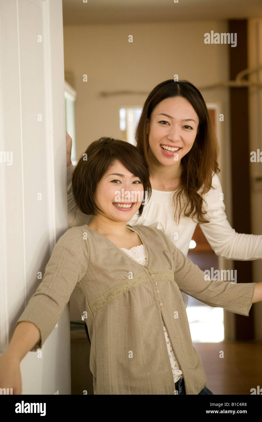 Two young women standing at entrance Stock Photo - Alamy