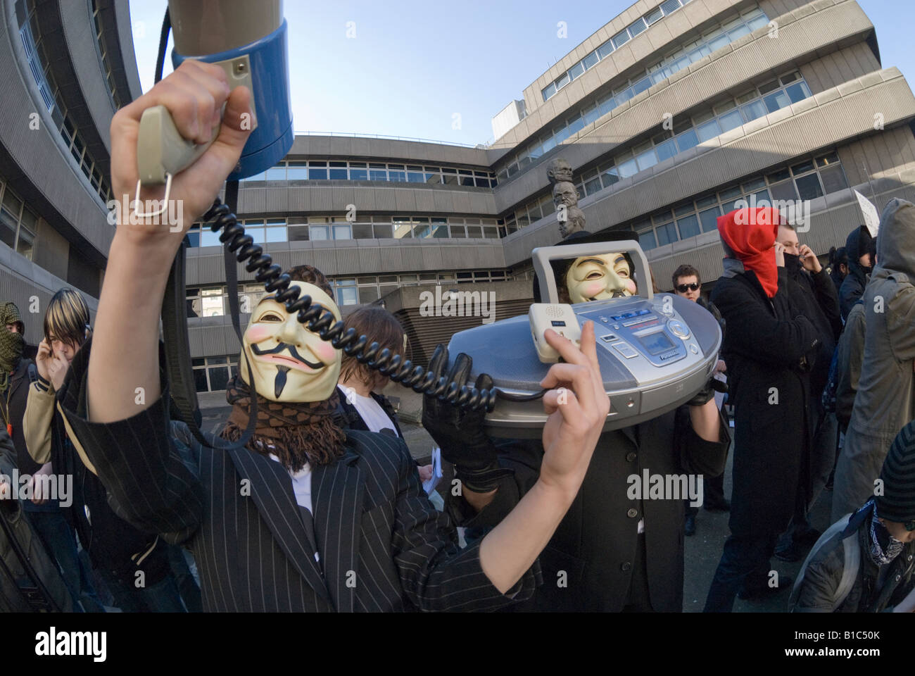 'Anonymous' protesters with megaphone and tape on balcony opposite ...