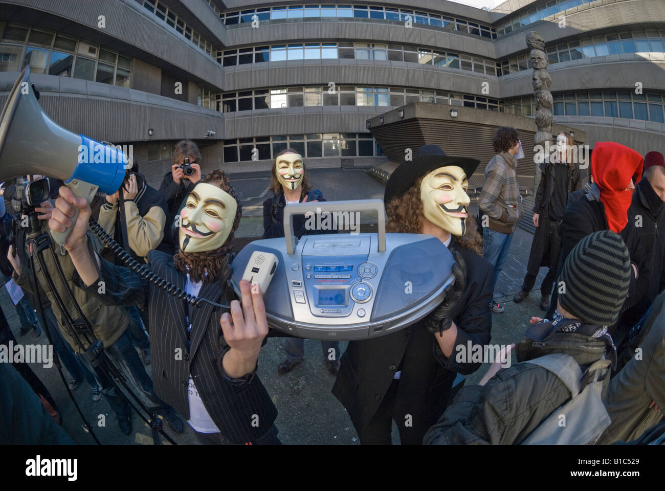 'Anonymous' protesters with megaphone and tape on balcony opposite ...