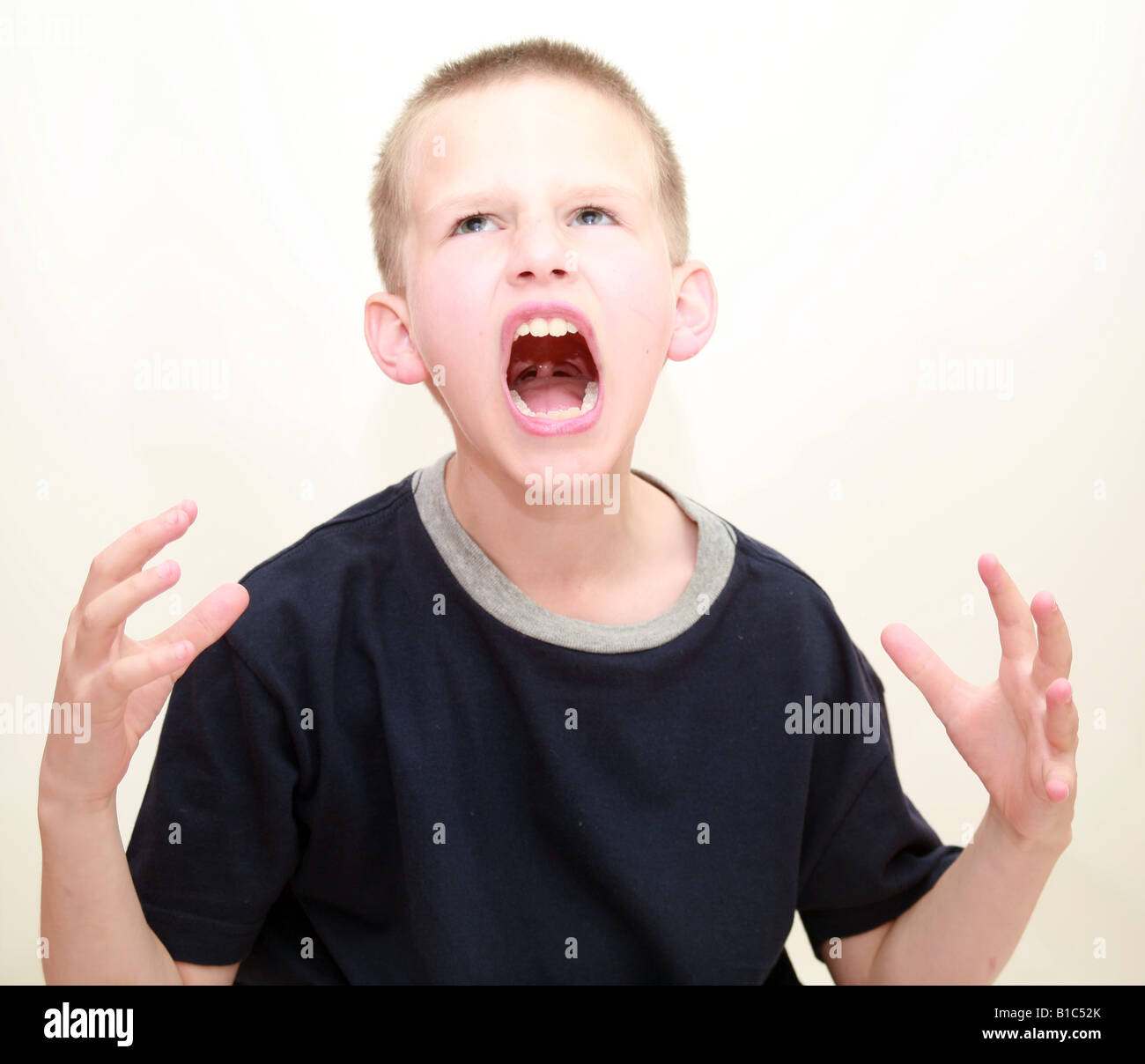 Boy in studio screaming with frustration or anger Stock Photo - Alamy