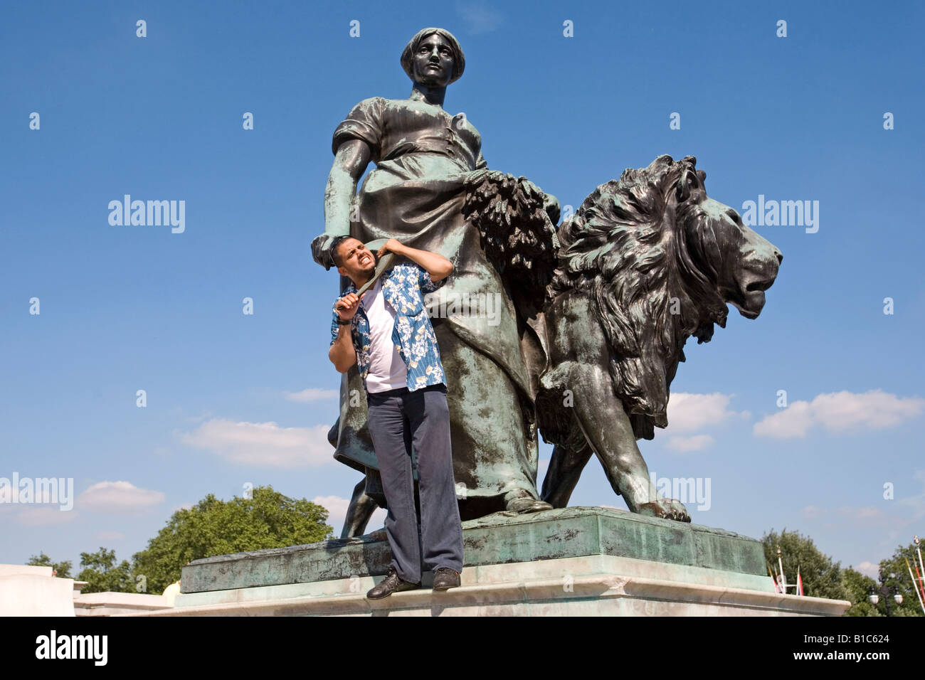 a man poses with a statue outside buckingham palace,london Stock Photo ...