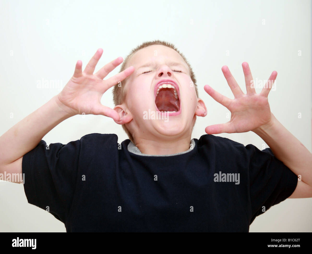 Boy in studio screaming with frustration or anger Stock Photo - Alamy