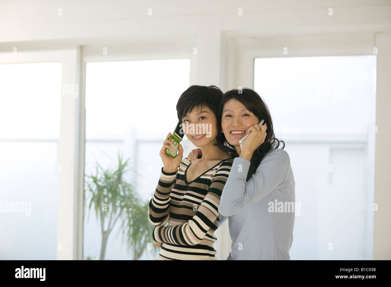 Two women using mobile phones Stock Photo - Alamy