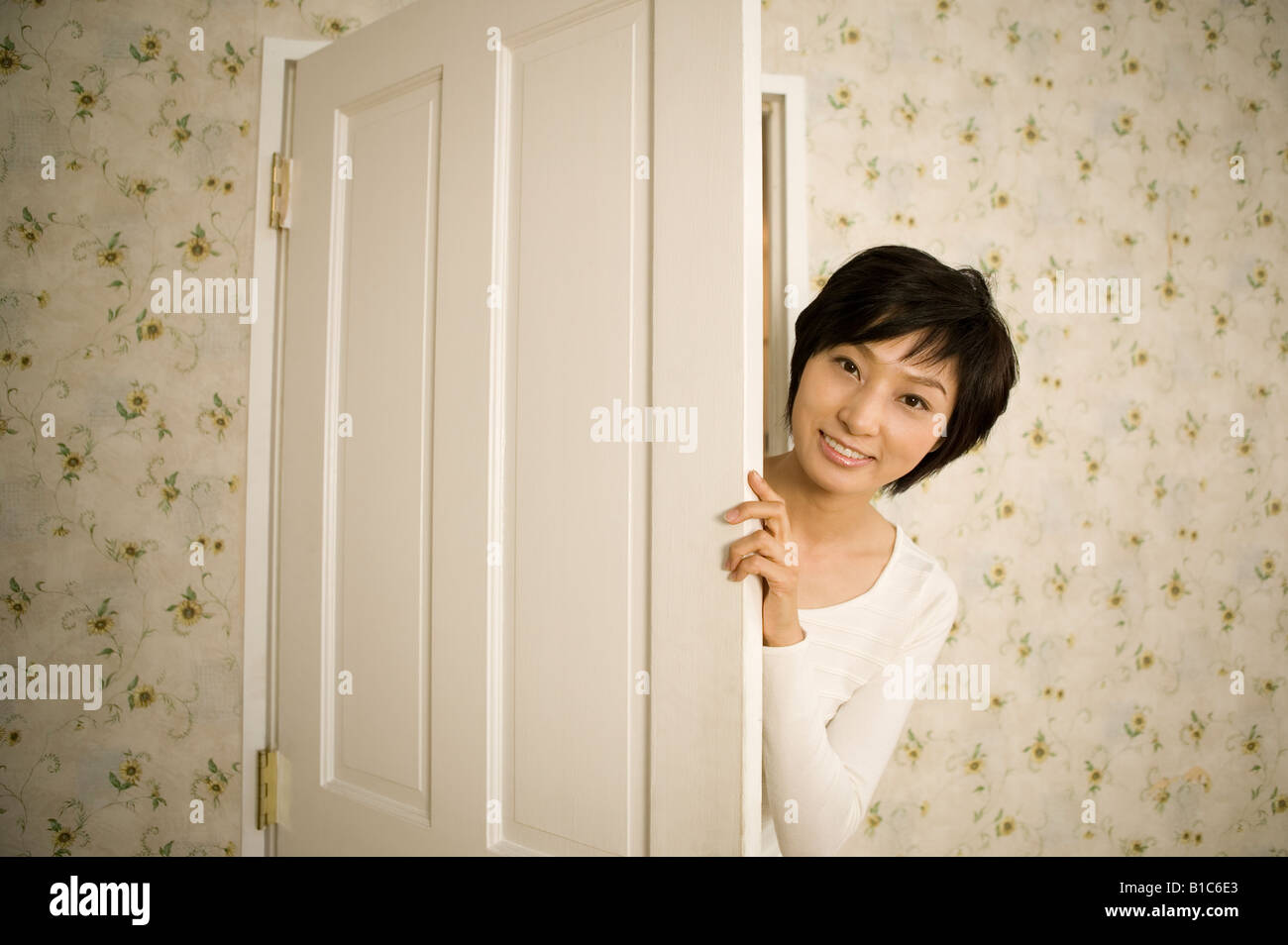 Young woman opening door Stock Photo - Alamy