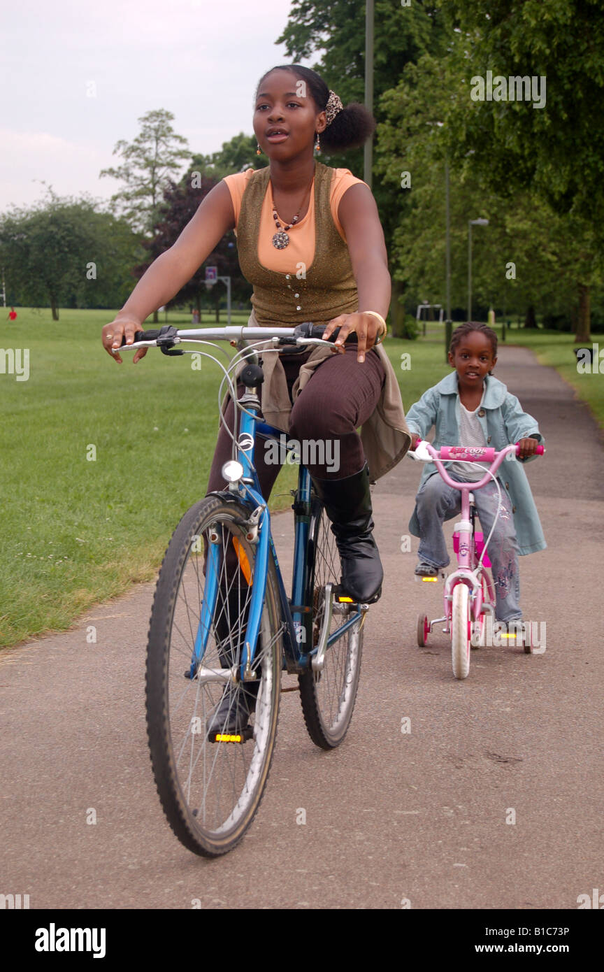 Afro-caribbean children riding bikes in park Stock Photo - Alamy