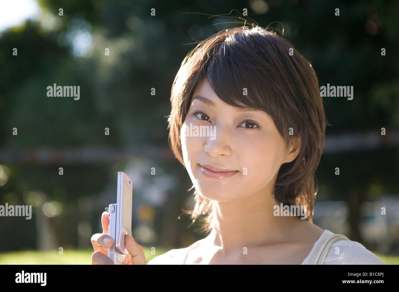 Young woman holding mobile phone Stock Photo - Alamy