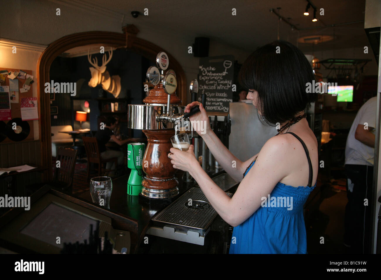 Bar worker pulling pints Stock Photo - Alamy