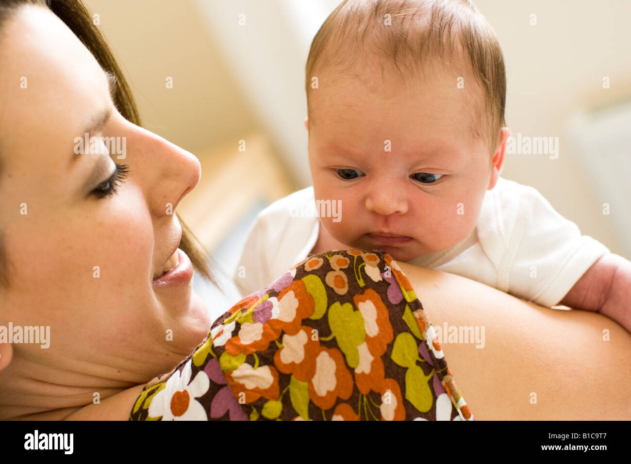 Baby looking over mothers shoulder Stock Photo - Alamy