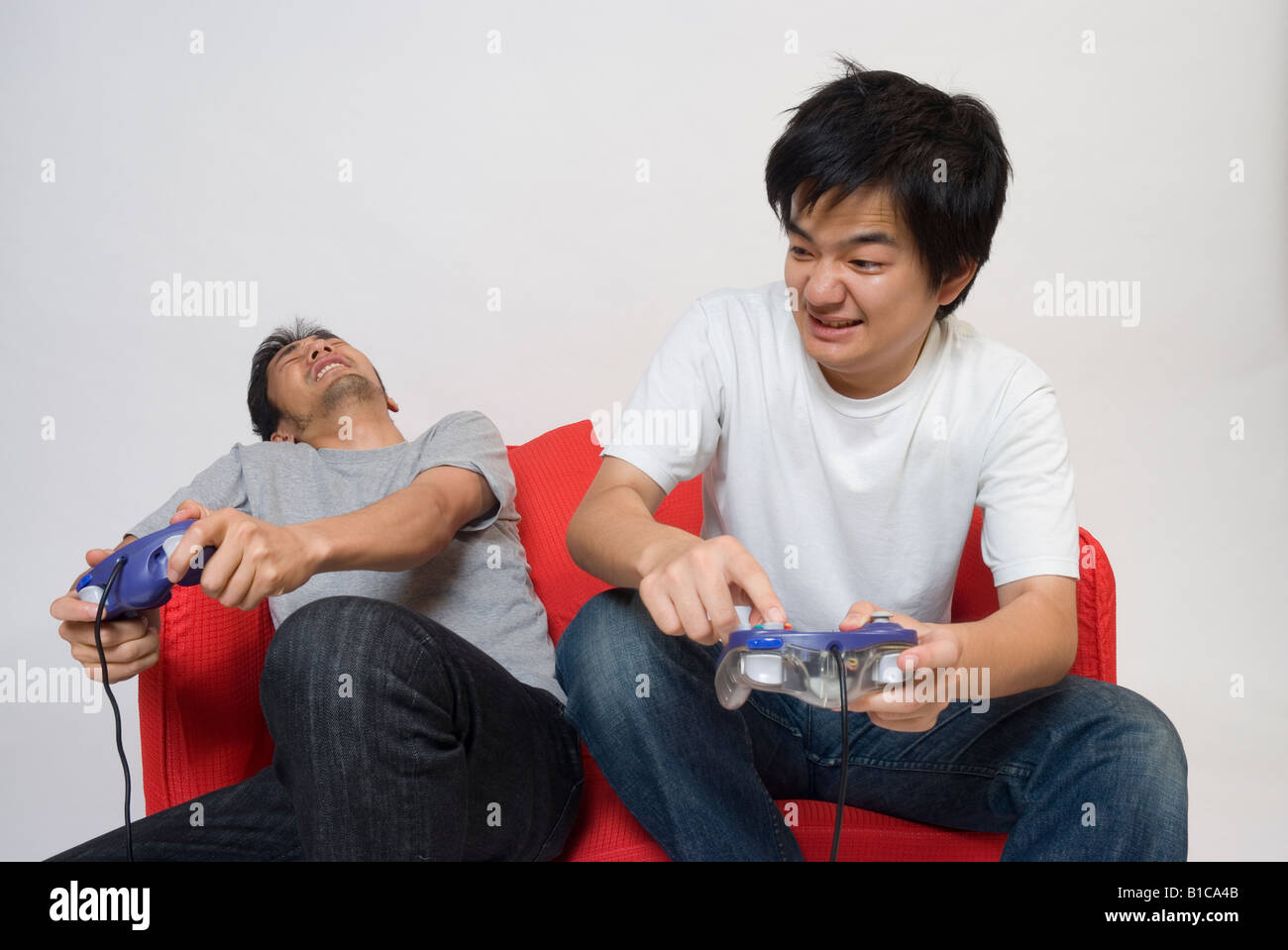 Two young men playing video game Stock Photo - Alamy