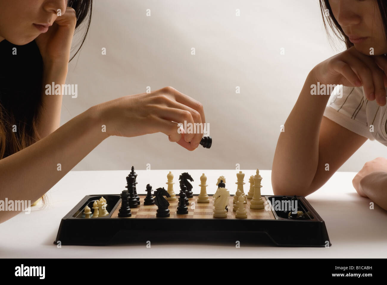 Two young women playing chess Stock Photo - Alamy