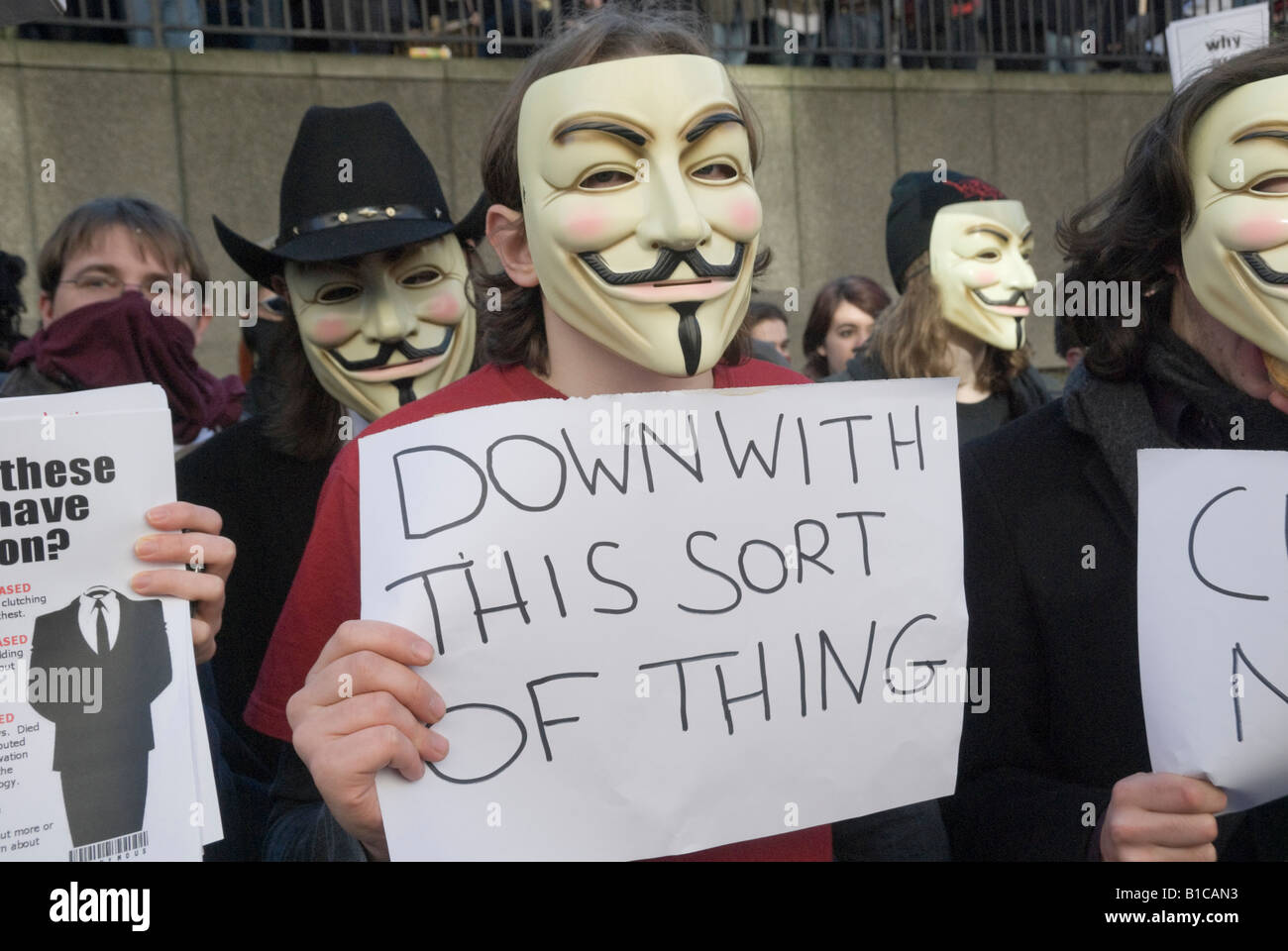 'Anonymous' protesters in masks hold placards 'Down with this sort of ...