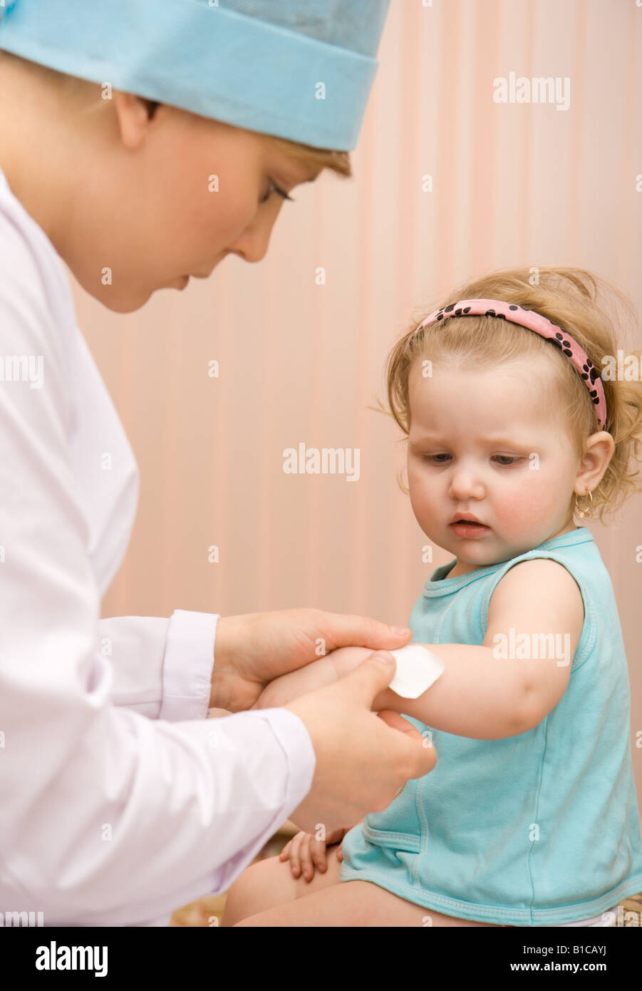 Doctor pediatrician putting a bandage on a little girl arm Stock Photo ...