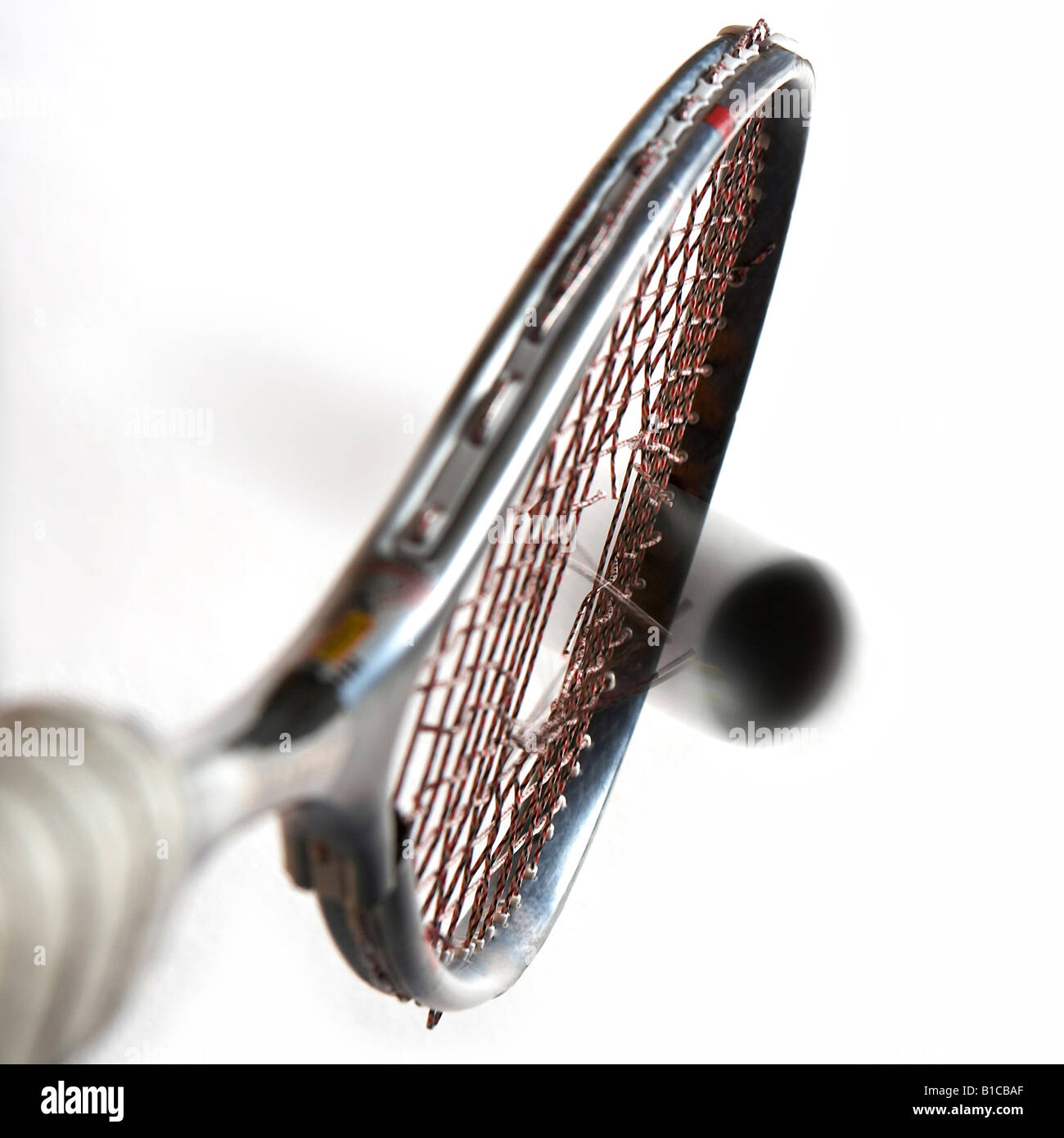 Action photo of Squash ball breaking through the strings of a squash ...