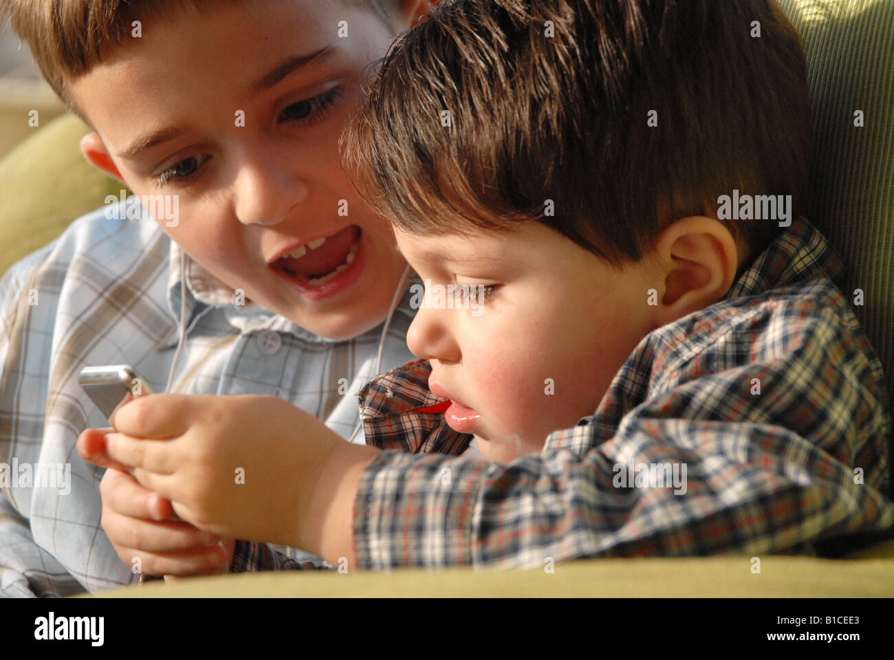 Ten year old boy shows his two year old cousin how to operate a new ...