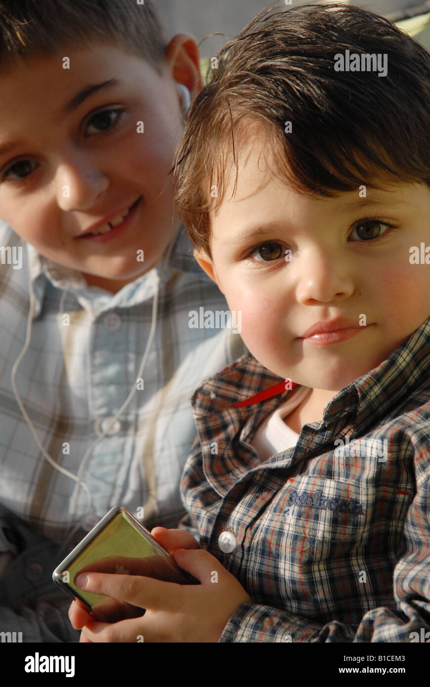 Ten year old boy shows his two year old cousin how to operate a new ...