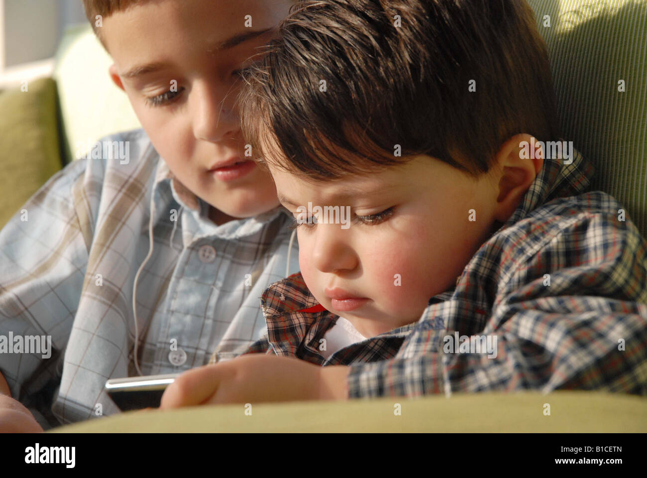 Ten year old boy shows his two year old cousin how to operate a new ...