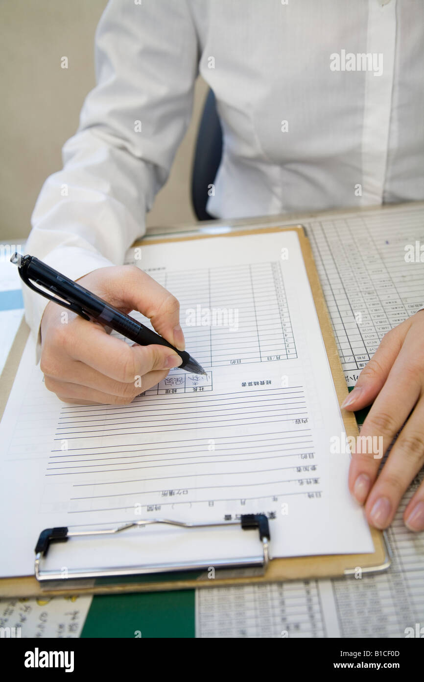 Young woman filling in sheet Stock Photo - Alamy