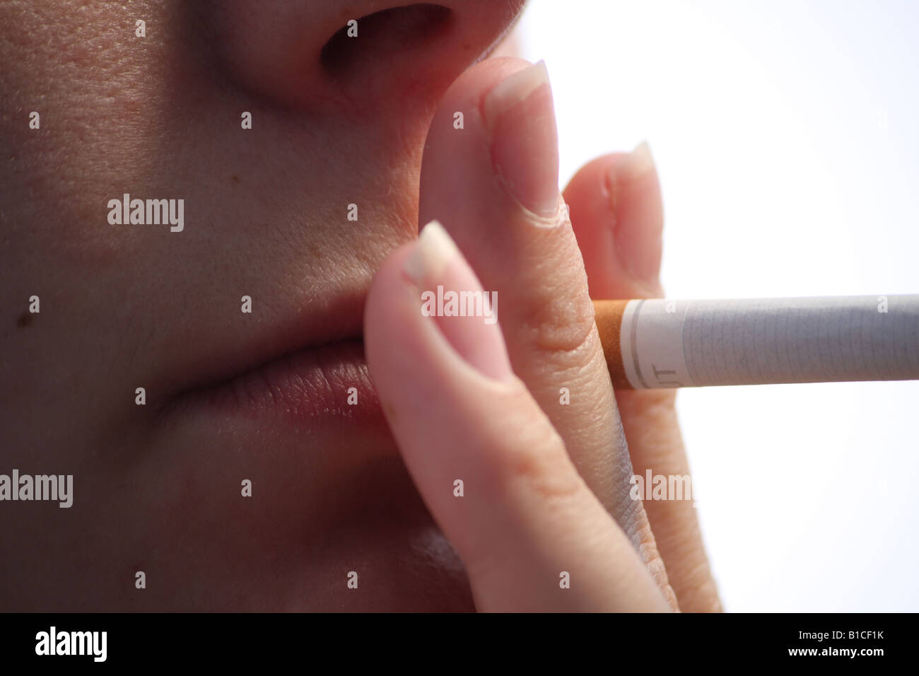 A young female inhaling a cigarette Stock Photo - Alamy