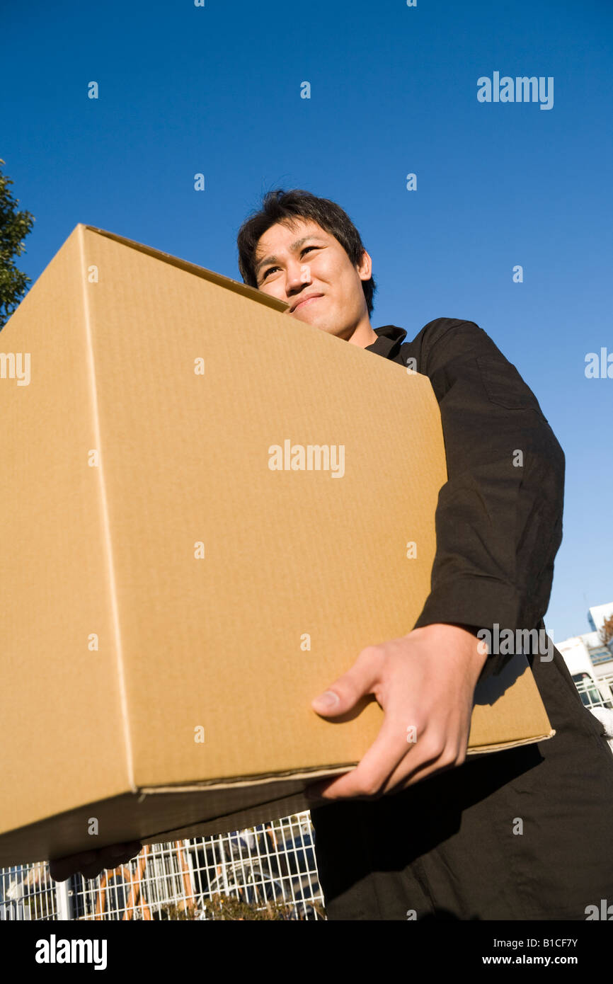 Young worker holding carton box Stock Photo - Alamy