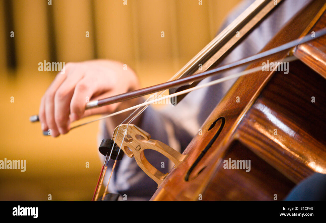 Close-up of the hands of a person playing the cello Stock Photo - Alamy