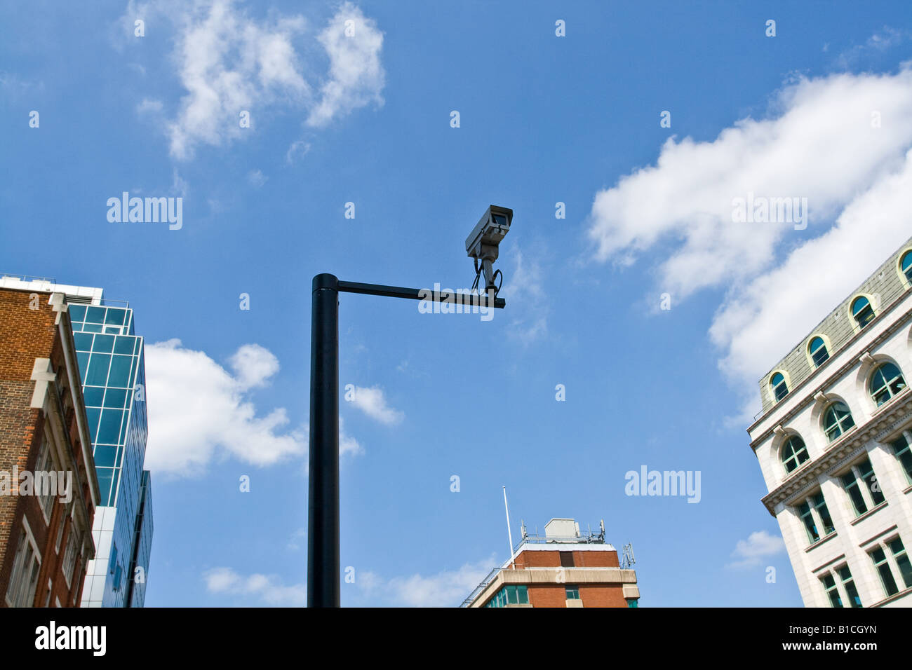 CCTV camera on high angular mast framed by buildings Stock Photo - Alamy