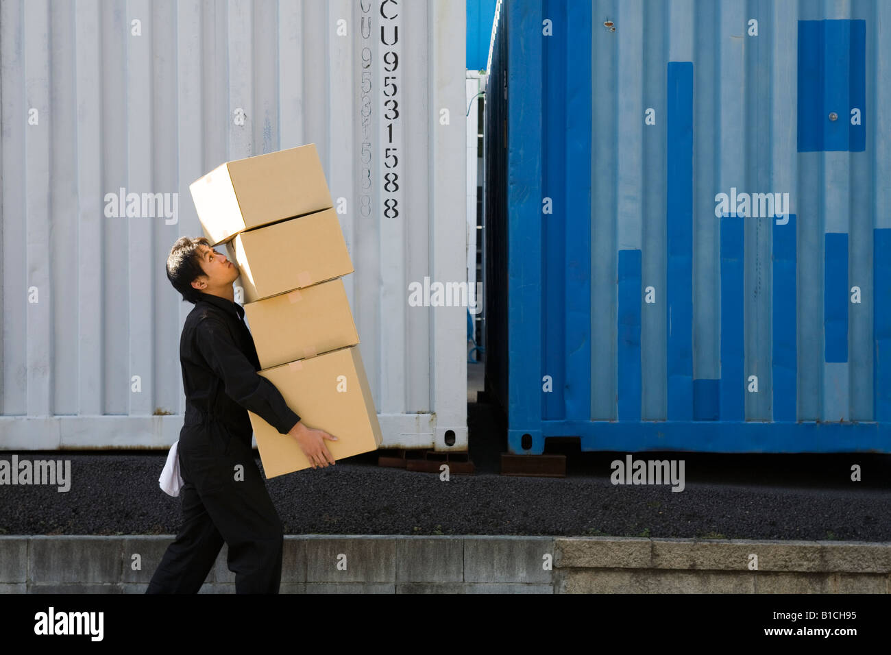 Young worker carrying boxes Stock Photo - Alamy