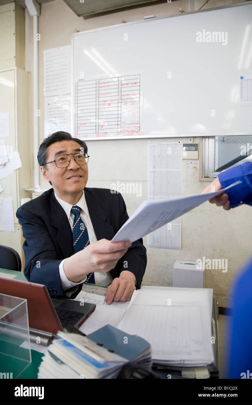 Mature businessman receiving document Stock Photo - Alamy