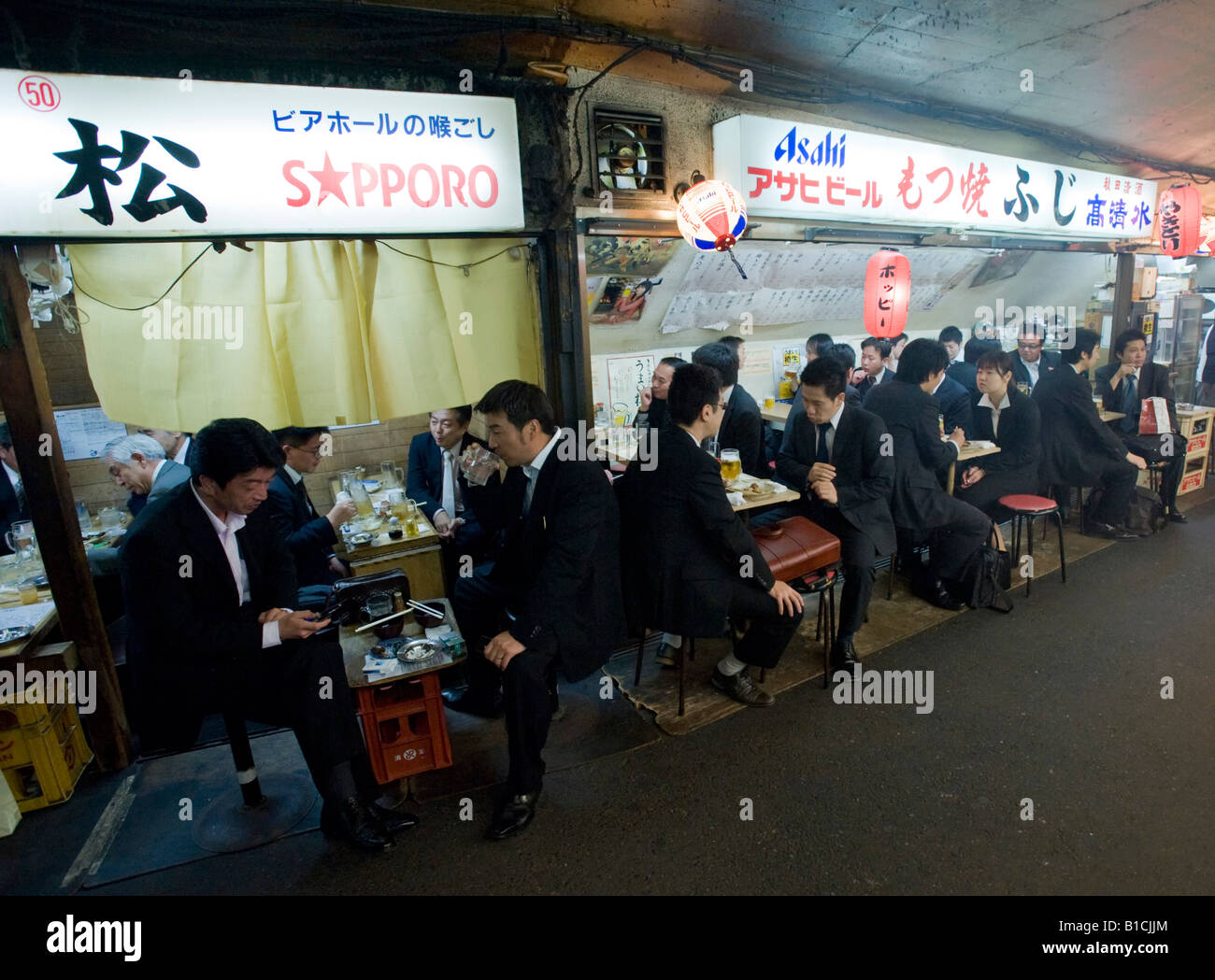 Busy Izakaya restaurants at night under railway arches in Yurakucho ...