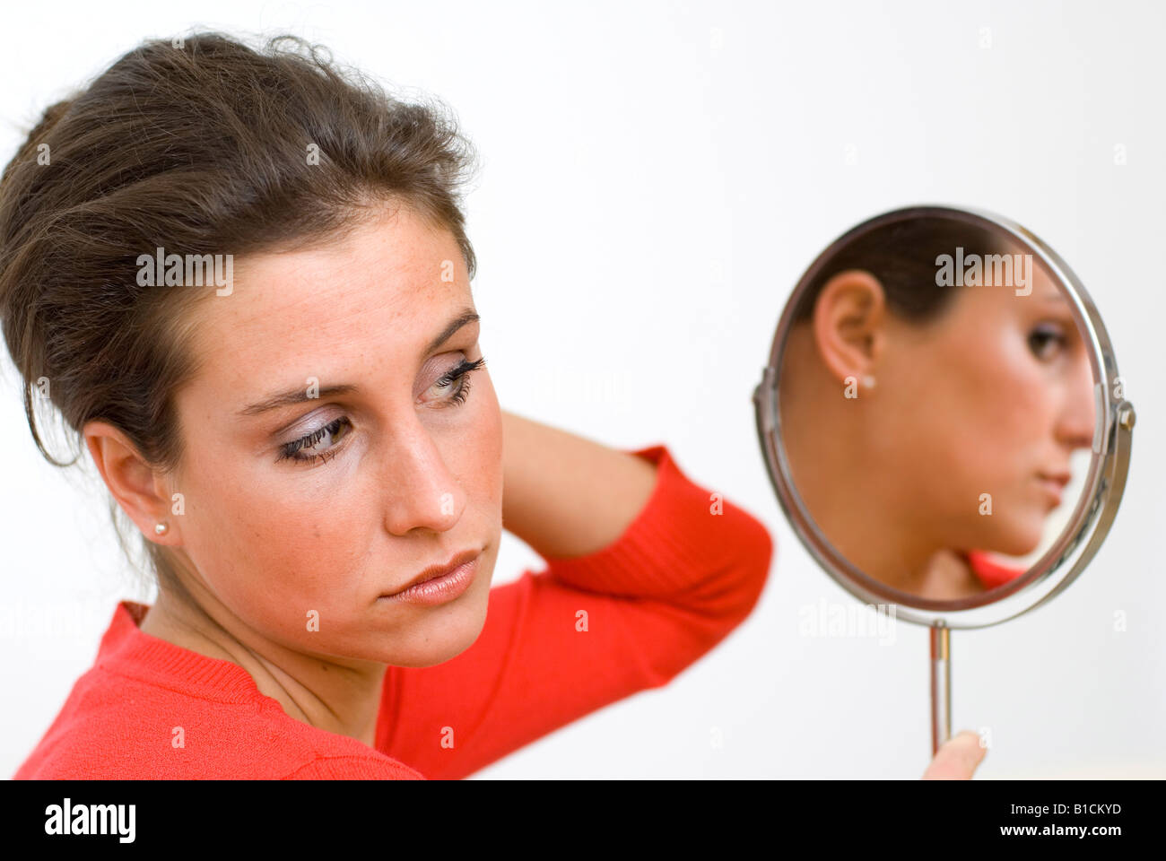 young woman looking at a hand mirror Stock Photo - Alamy