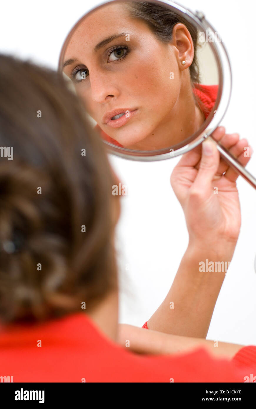 woman looking at a hand mirror Stock Photo - Alamy