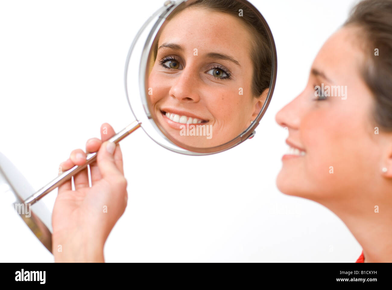 young woman looking at a hand mirror Stock Photo - Alamy