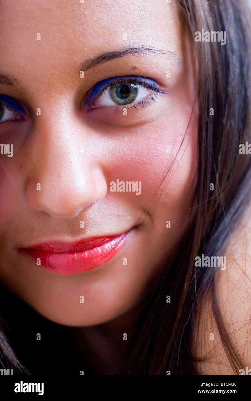 young heavily rouged woman with long brown hair and red lips, smiling ...