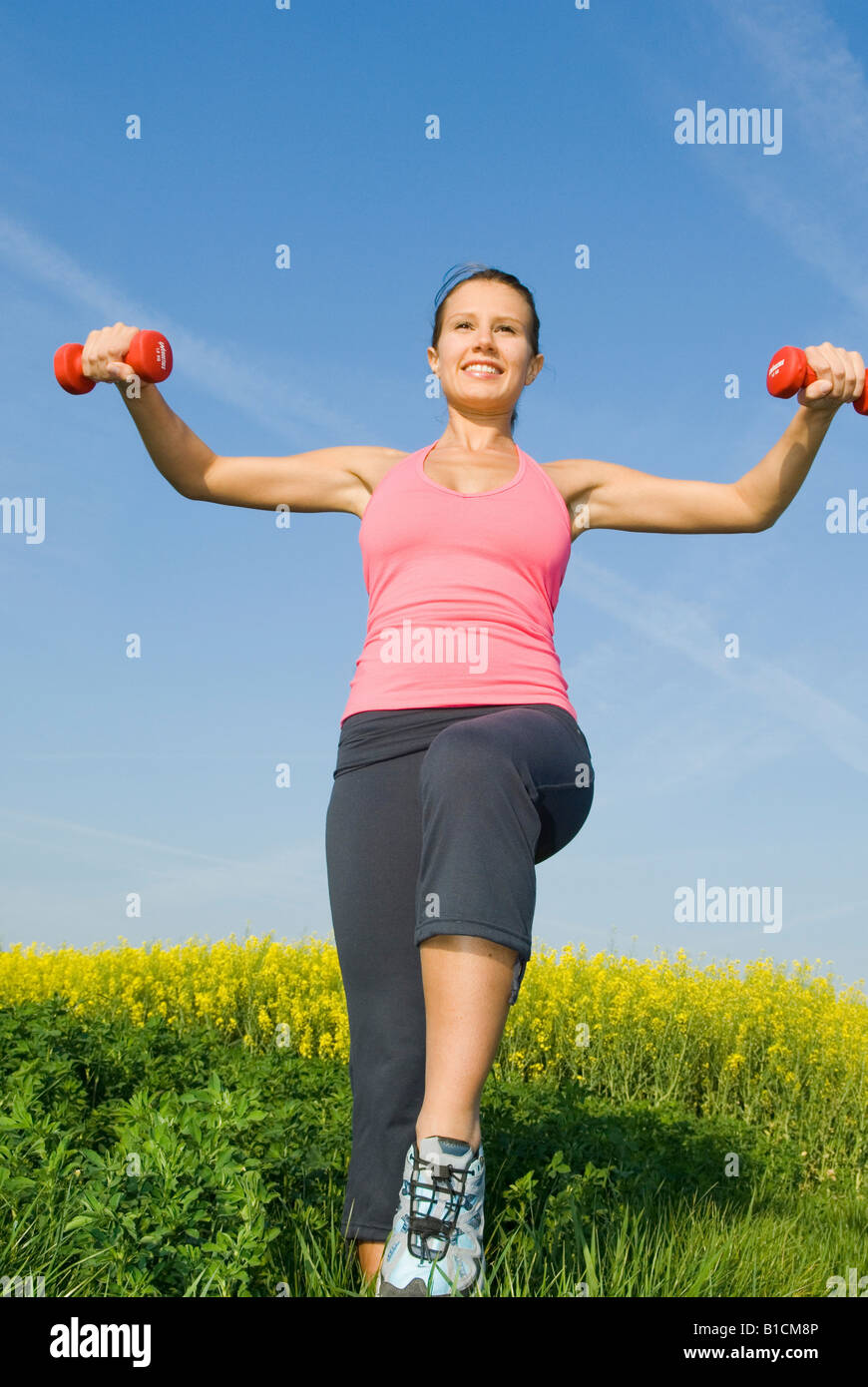 young woman lifting barbells outdoor, Cardio-Moves Stock Photo - Alamy