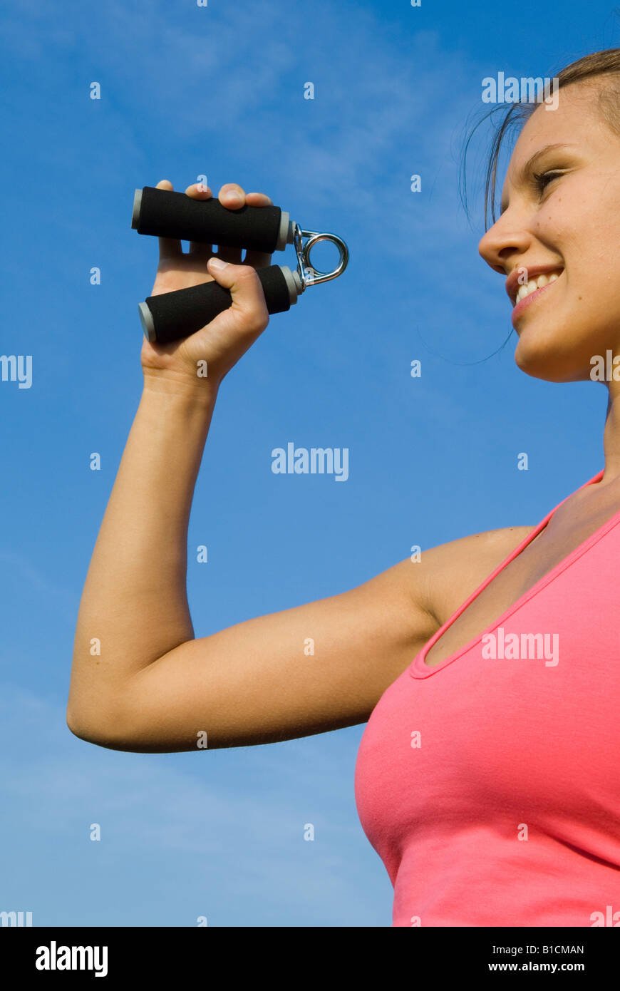 young woman exercising with handgrips Stock Photo - Alamy