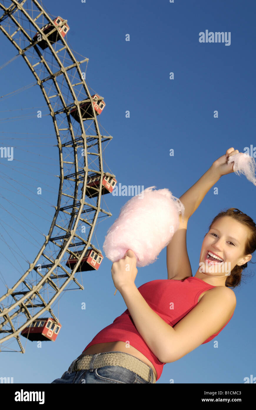 happy young woman with candy floss in front of the Wiener Riesenrad auf ...
