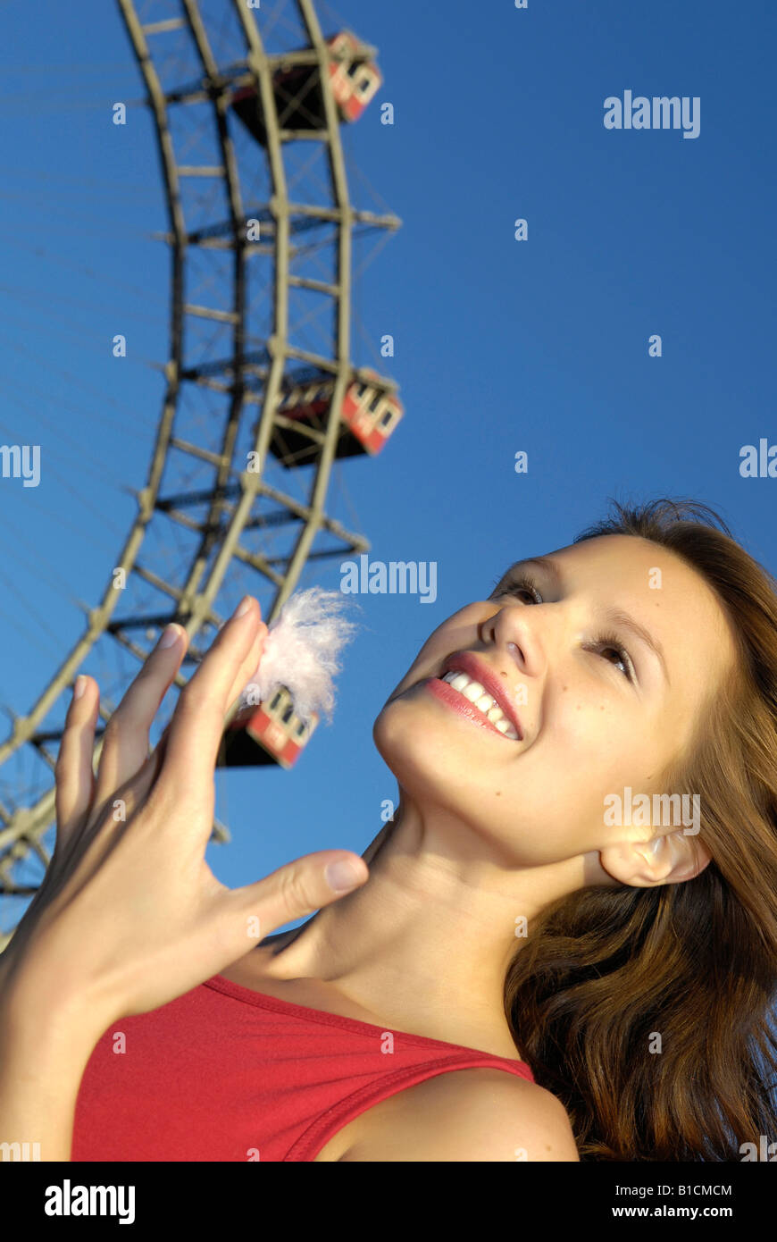 happy young woman with candy floss in front of the Wiener Riesenrad auf ...