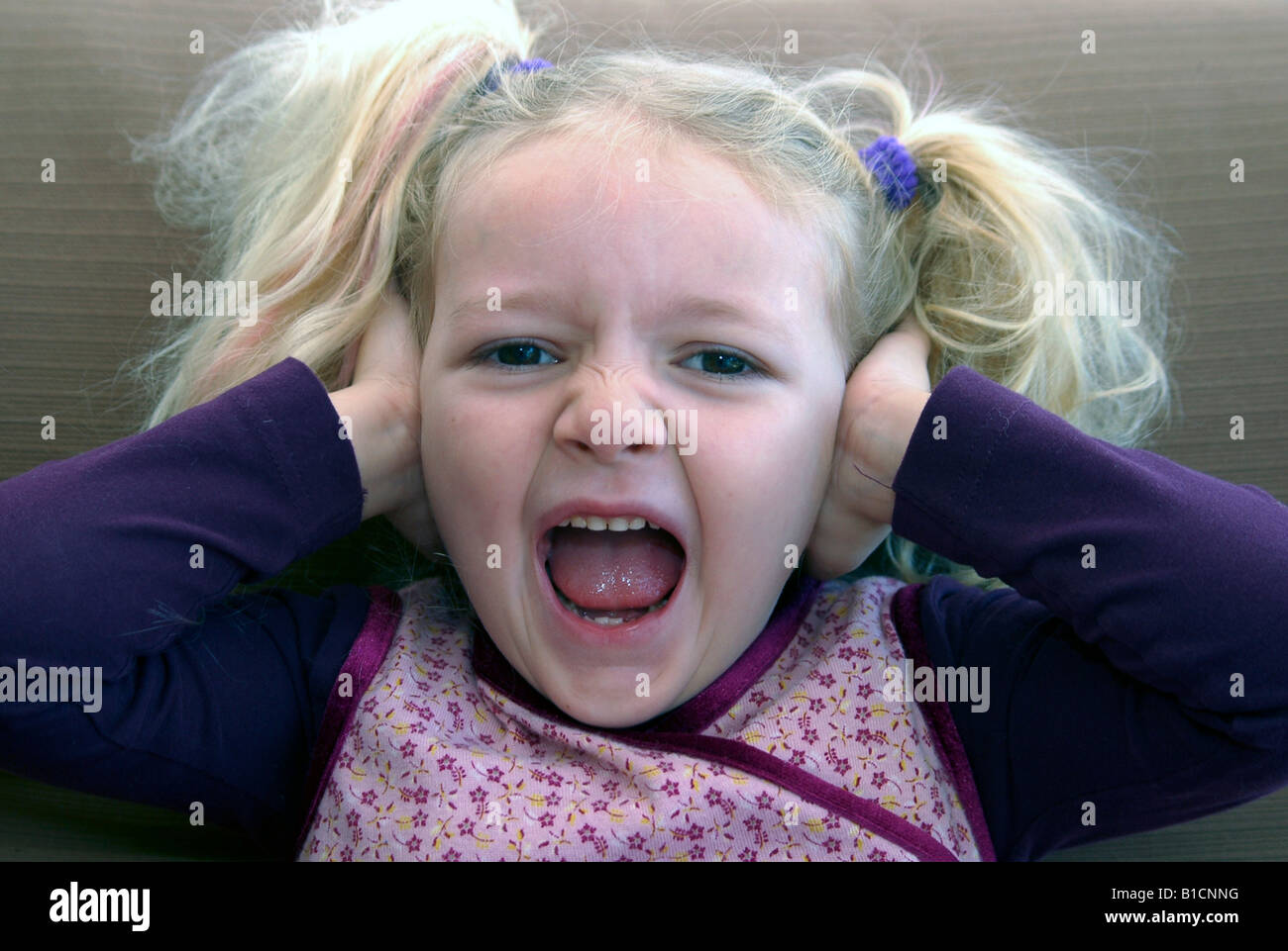 screaming girl keeps ears shut Stock Photo - Alamy