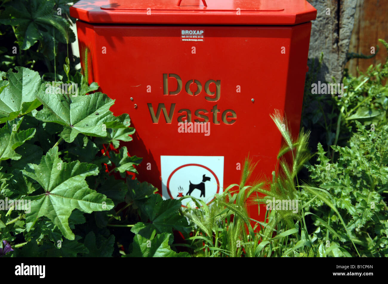 Bright red dog waste bin UK Stock Photo - Alamy