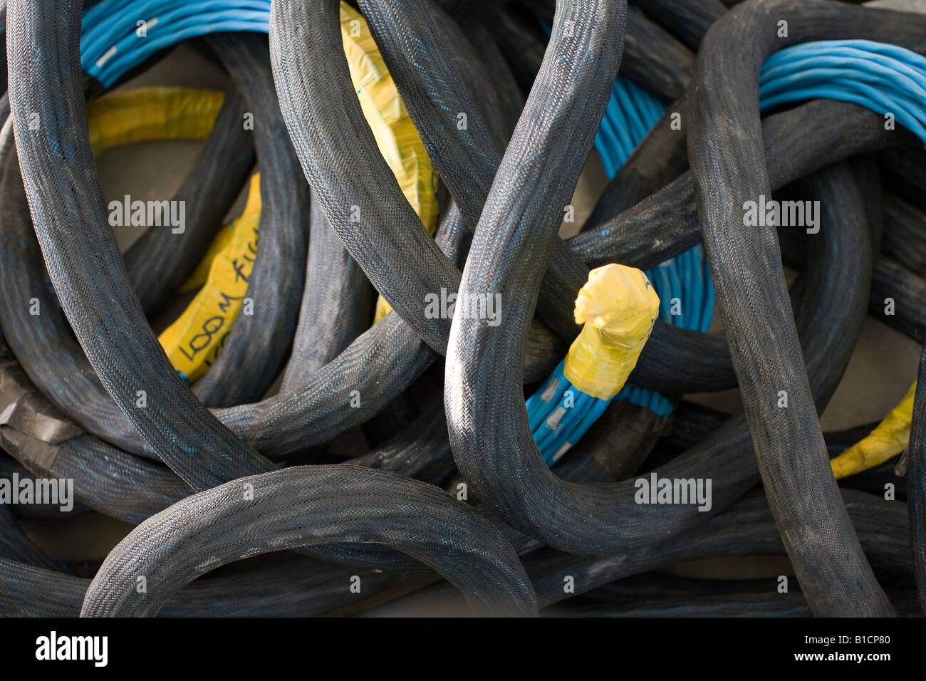 Data cables being unstalled in a modern office are covered in charcoal ...